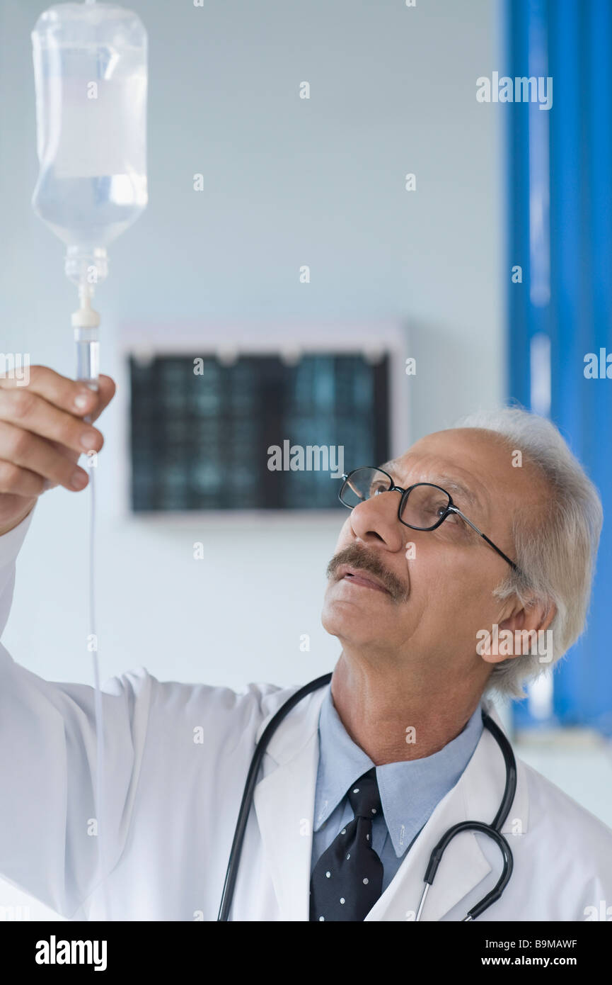 Doctor checking a saline drip Stock Photo - Alamy