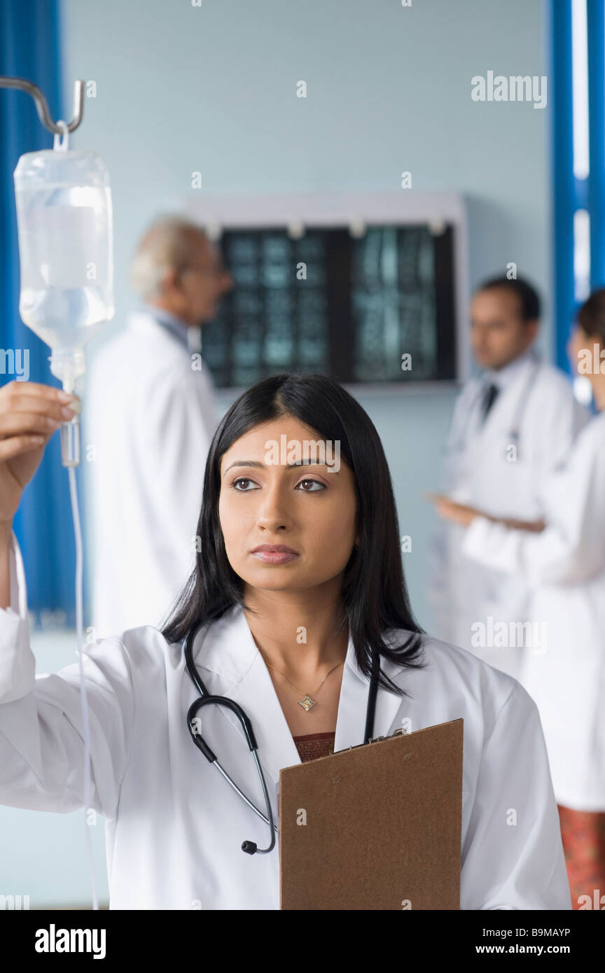 Female doctor examining an IV drip Stock Photo - Alamy