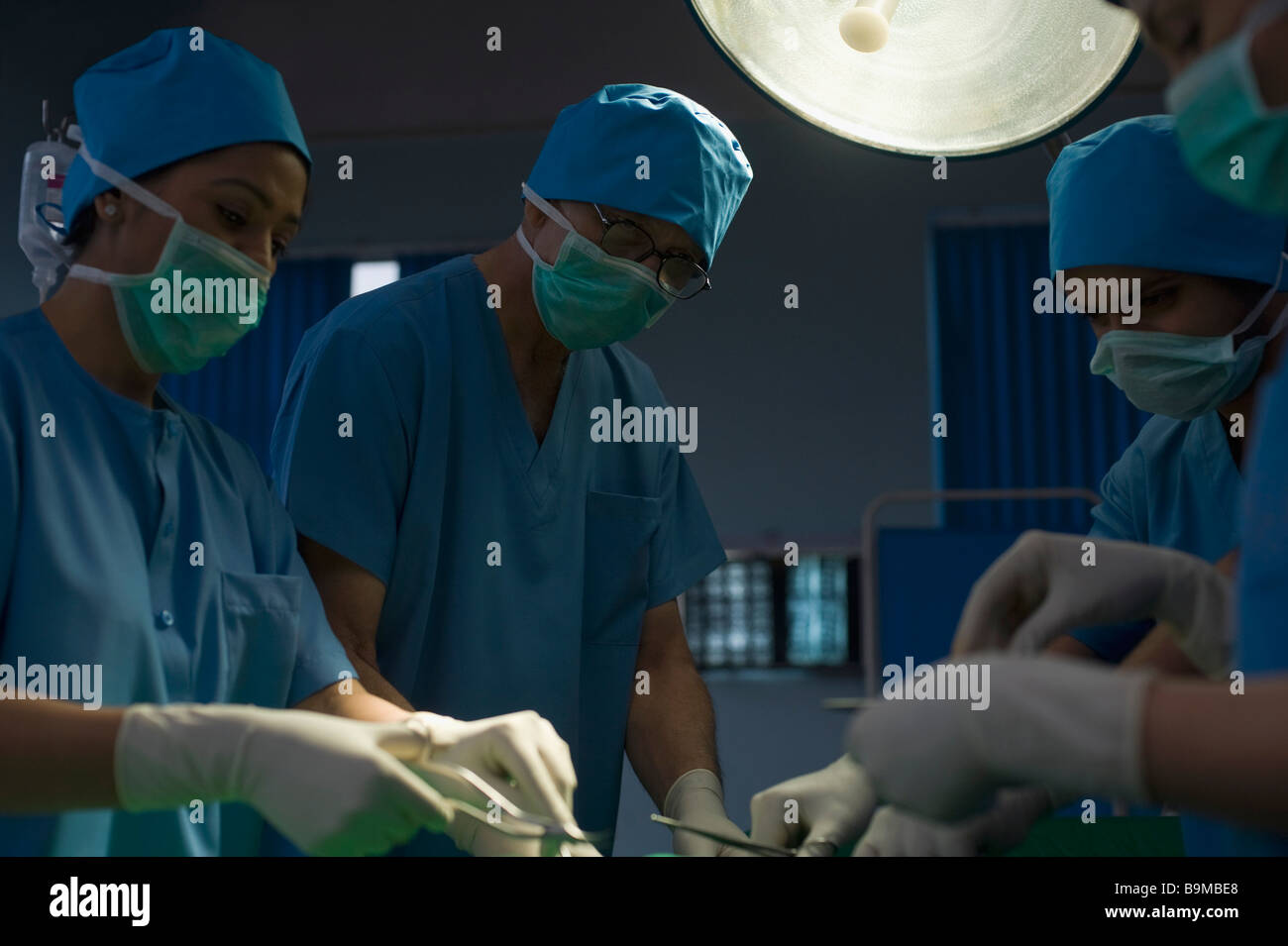 Surgeons performing a surgery in an operating room Stock Photo - Alamy