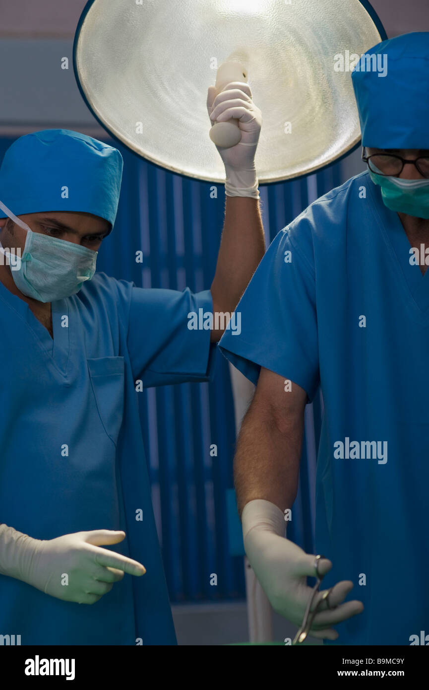 Two surgeons performing a surgery in an operating room Stock Photo - Alamy
