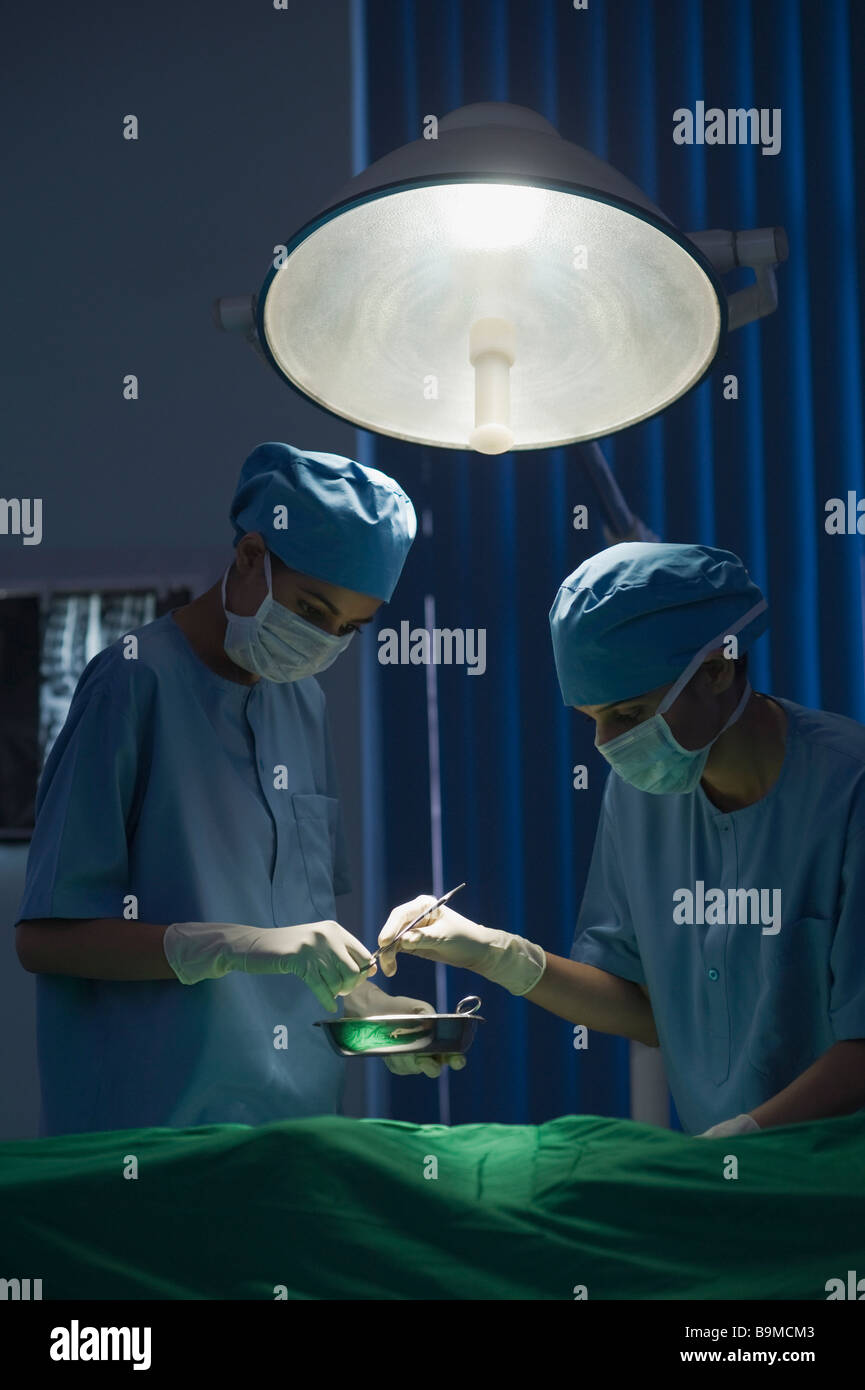 Two Female Surgeons Performing A Surgery In An Operating Room Stock