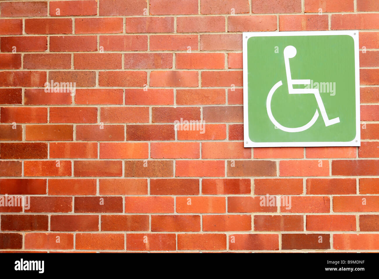 Disabled access sign on red brick wall Stock Photo - Alamy