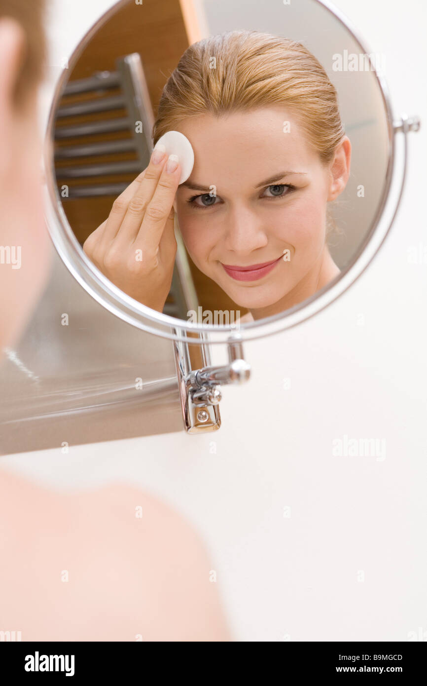 Young pretty woman cleaning face using cotton pad Stock Photo - Alamy