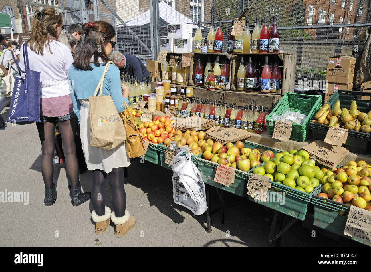 Girls at apple stall Islington Farmers Market London England UK Stock ...