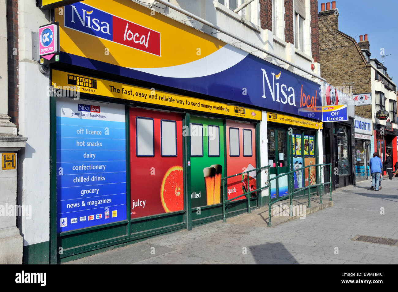 Shopper outside Nisa business & local convenience store shop front ...