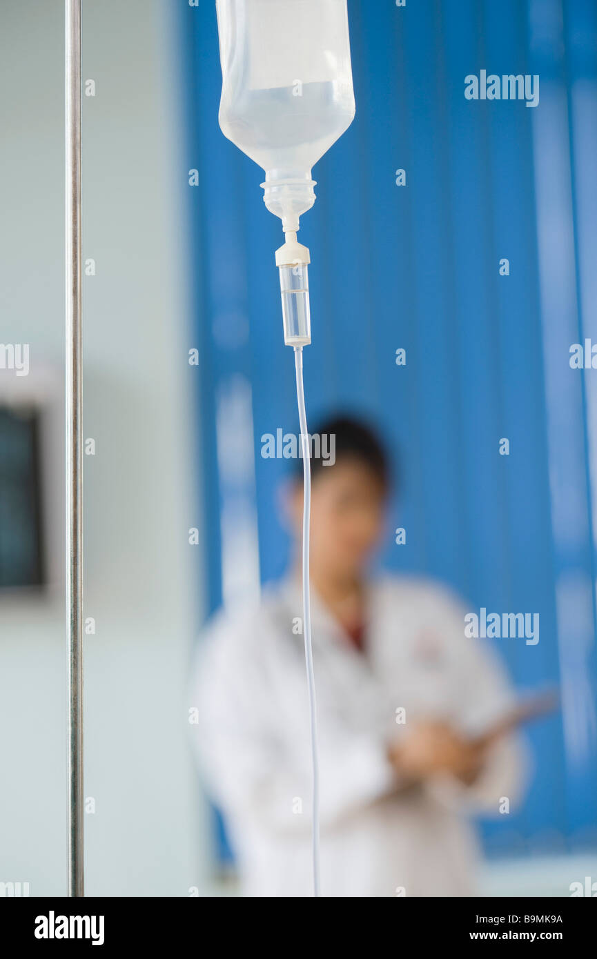 Saline drip on a stand with a female doctor in the background Stock ...