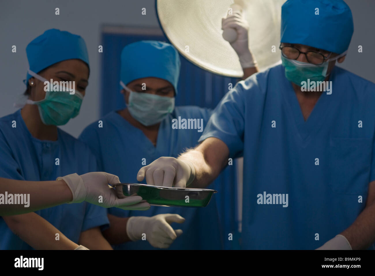 Surgeons performing a surgery in an operating room Stock Photo - Alamy
