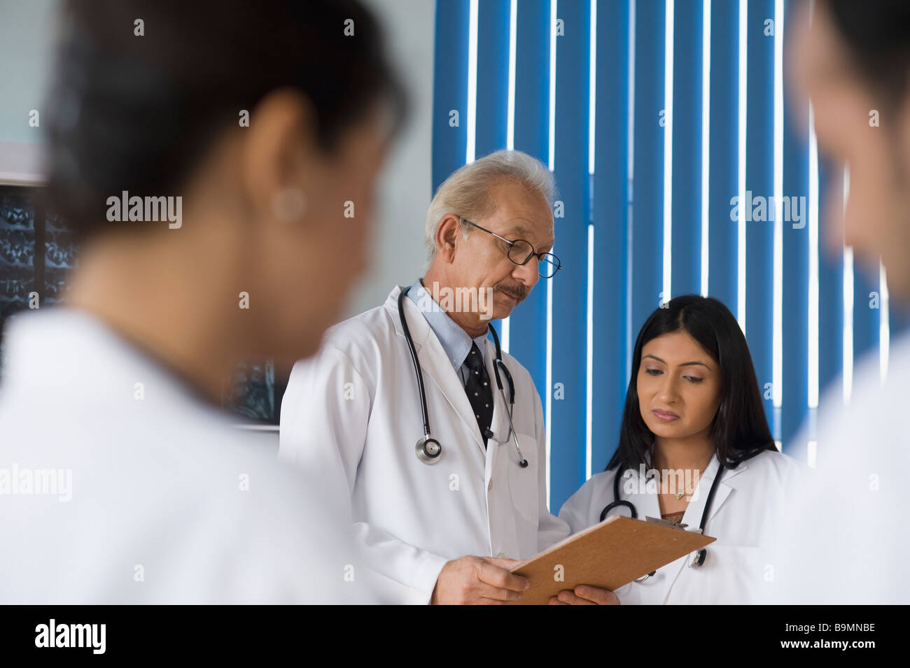 Doctors examining a report Stock Photo - Alamy