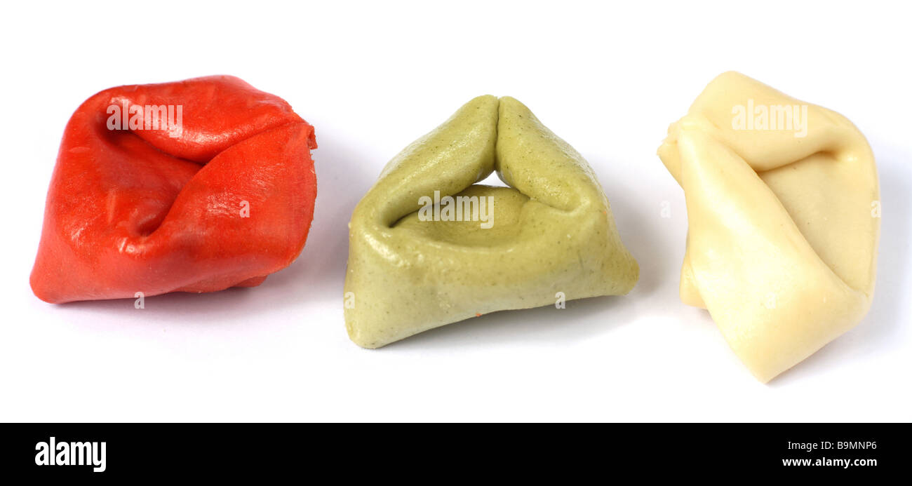 A macro photo of individual stuffed tortellini shells colored red and ...