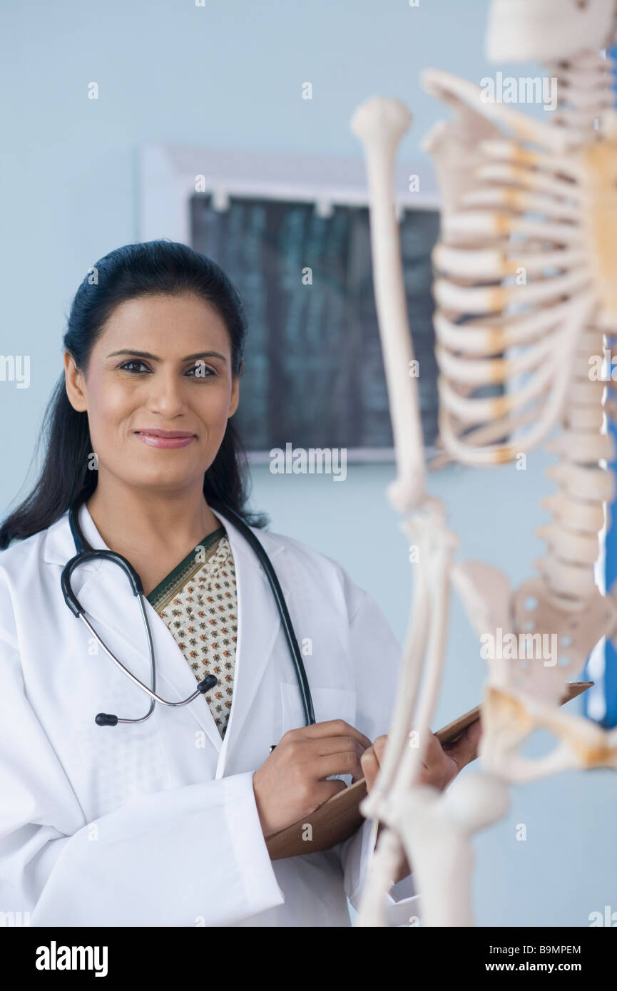 Female doctor standing in front of a human skeleton model Stock Photo ...