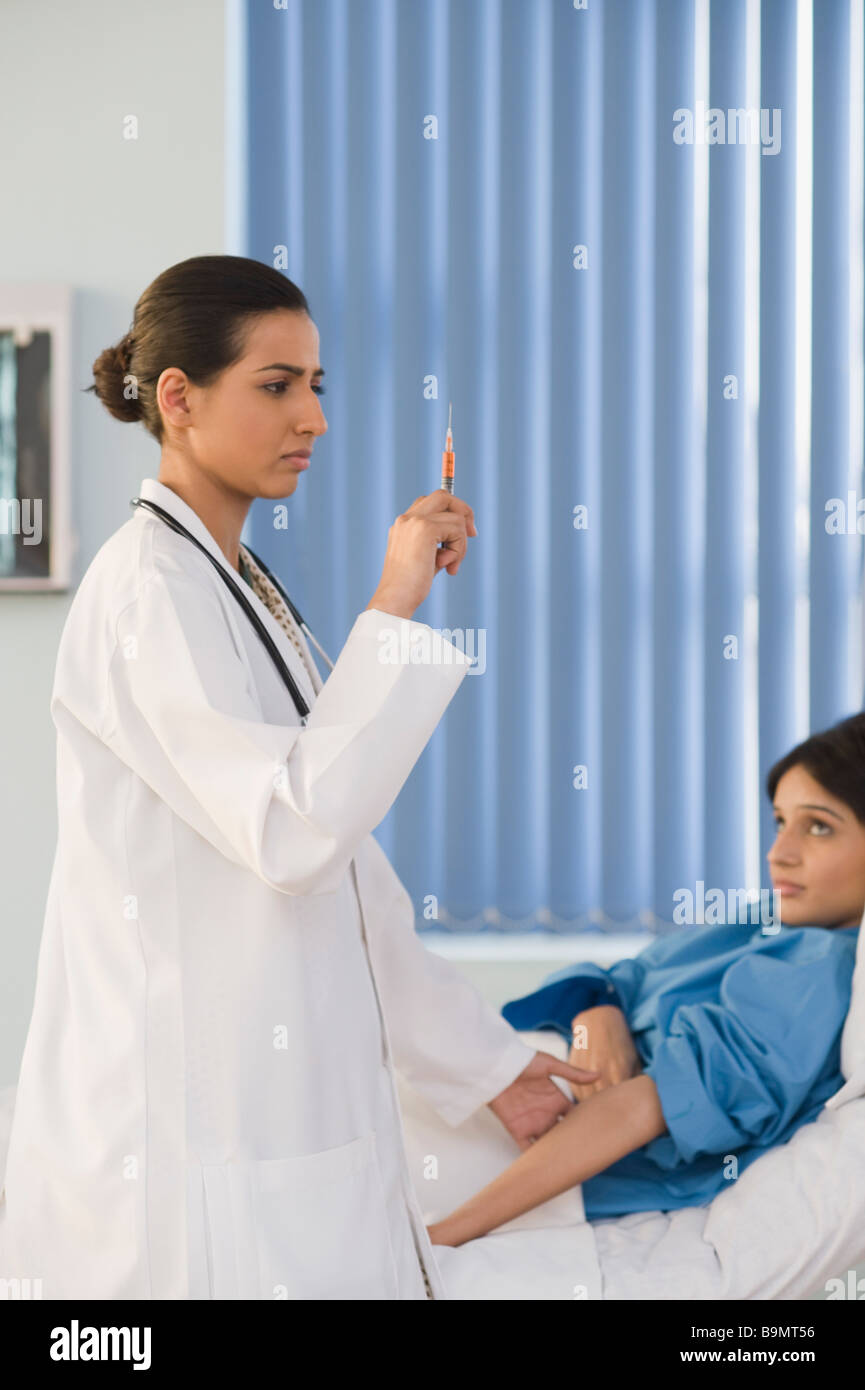 Female doctor injecting medicine to a patient Stock Photo - Alamy