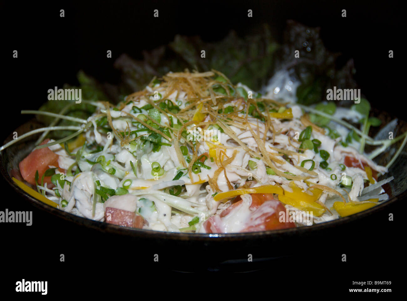 A creamy salad or julienned daikon radish and tomatoes and chicken is ...