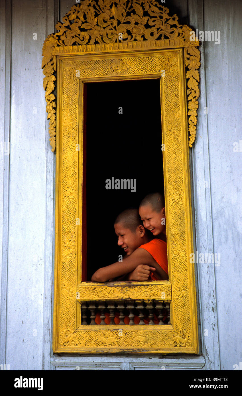 Laos, Luang Prabang, Wat Yat Luang Temple, novice monks at a window ...