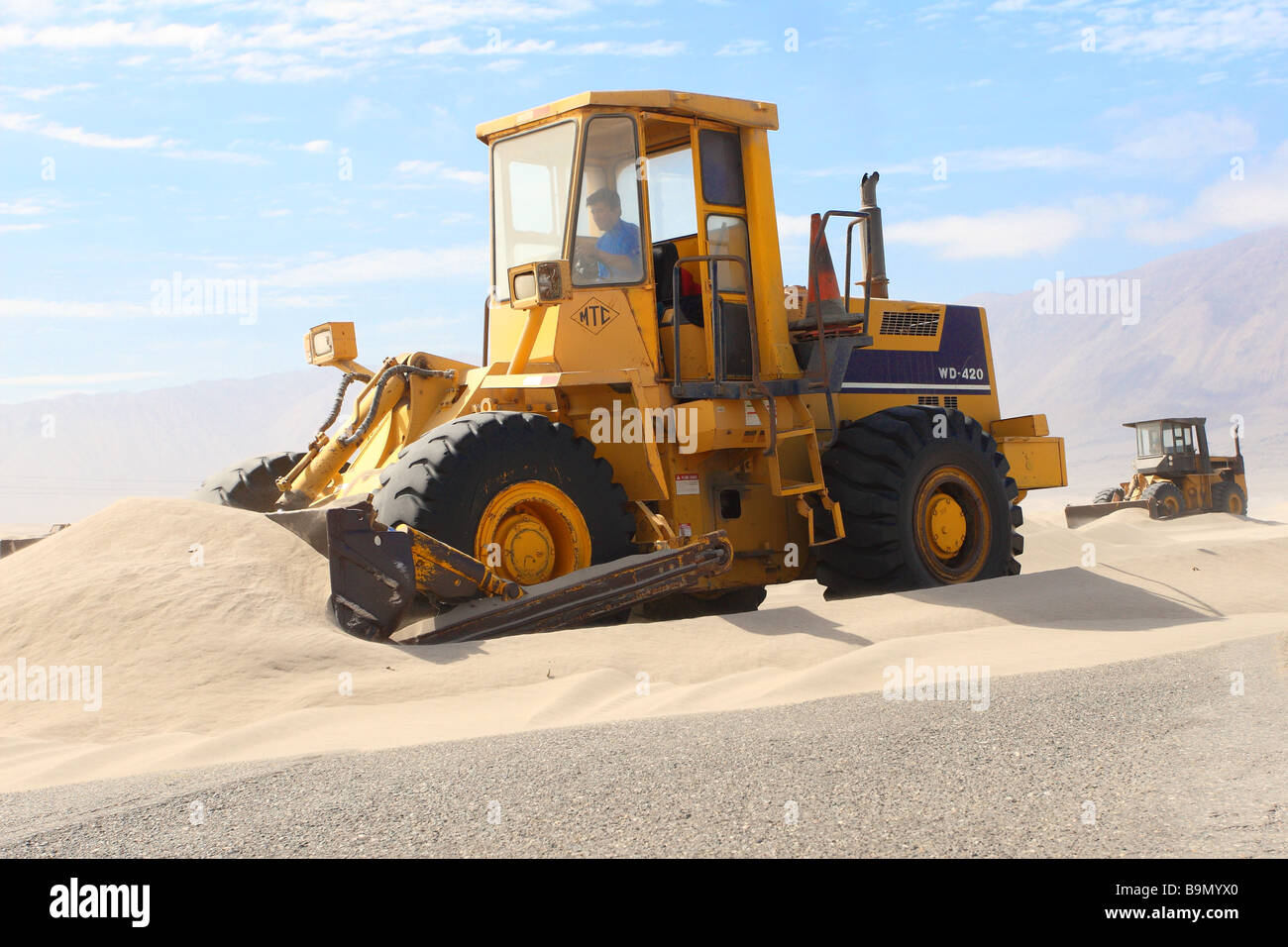 bulldozer work to move desert sand from the main street, peru Stock ...