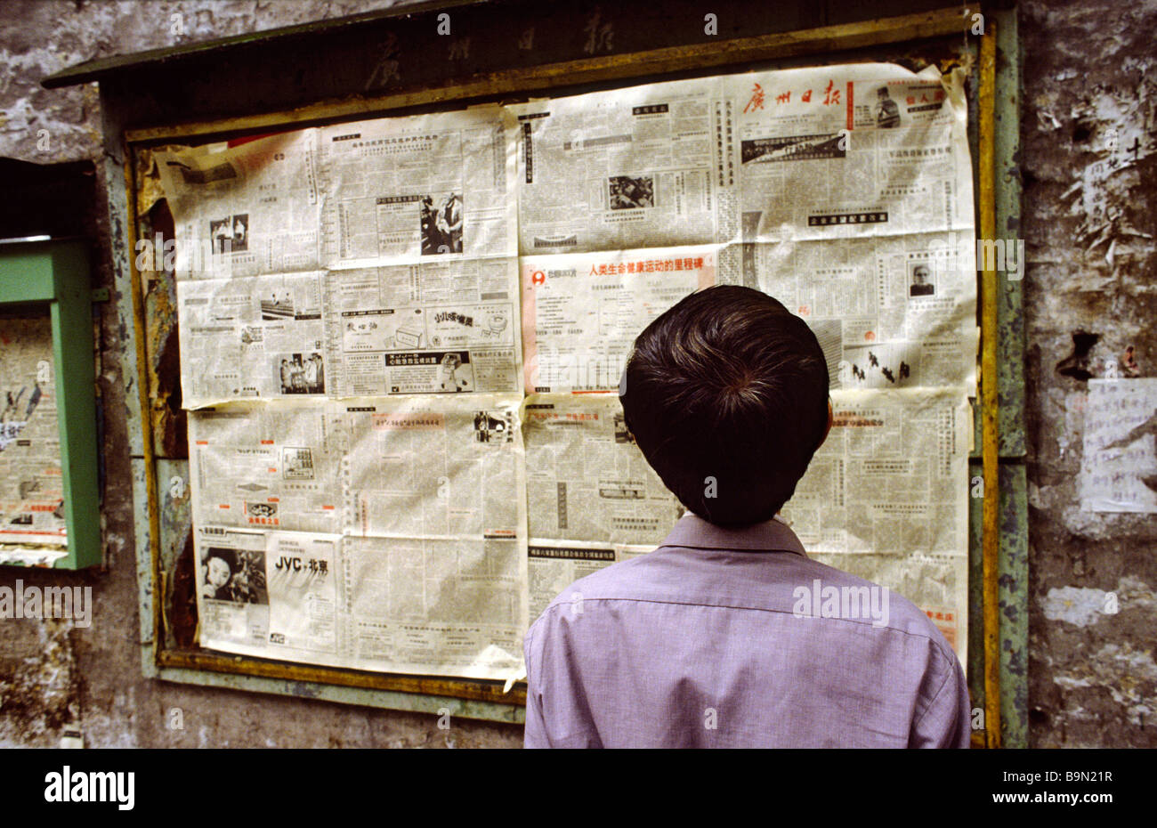 China, Guangdong Province, Canton (Guangzhou), man reading a newspaper ...