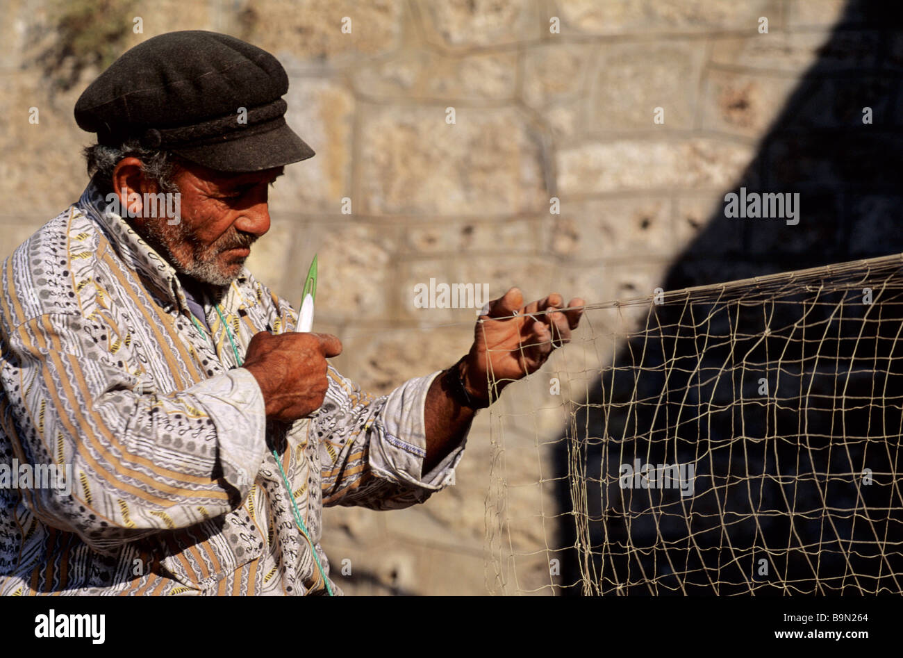 Turkey, Mediterranean region, Antalya, fisherman mending his net in the ...