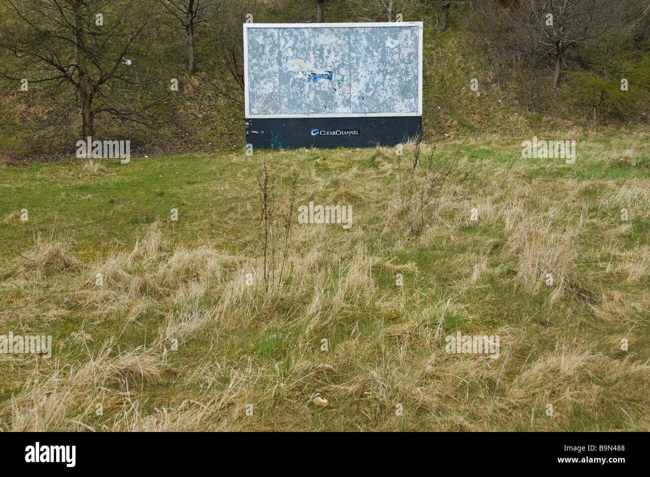 Empty and tattered ClearChannel advertising billboard on waste ground ...
