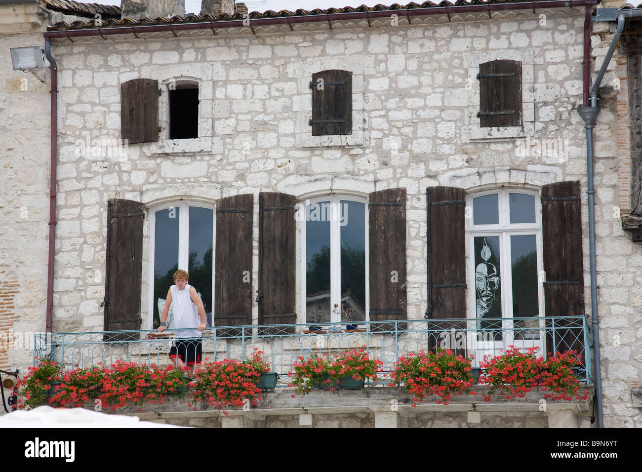 A boy and a painting both look out onto the square in Eymet, France ...