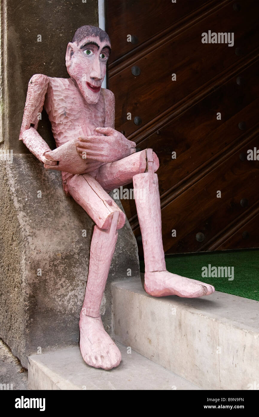 Seating man wooden sculpture Stock Photo - Alamy