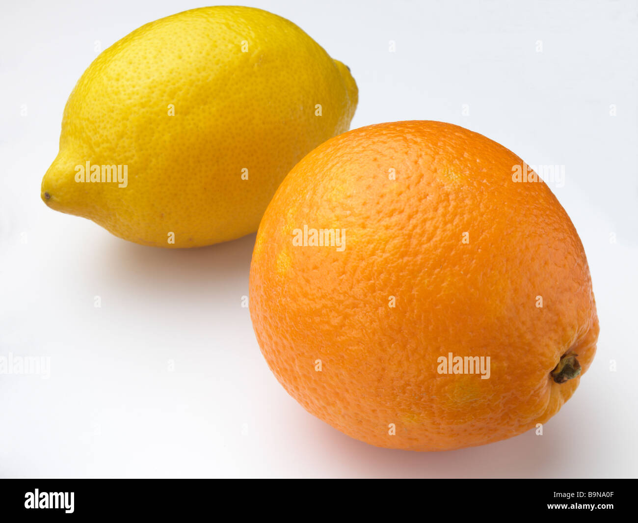 An orange and a lemon on a white background Stock Photo - Alamy