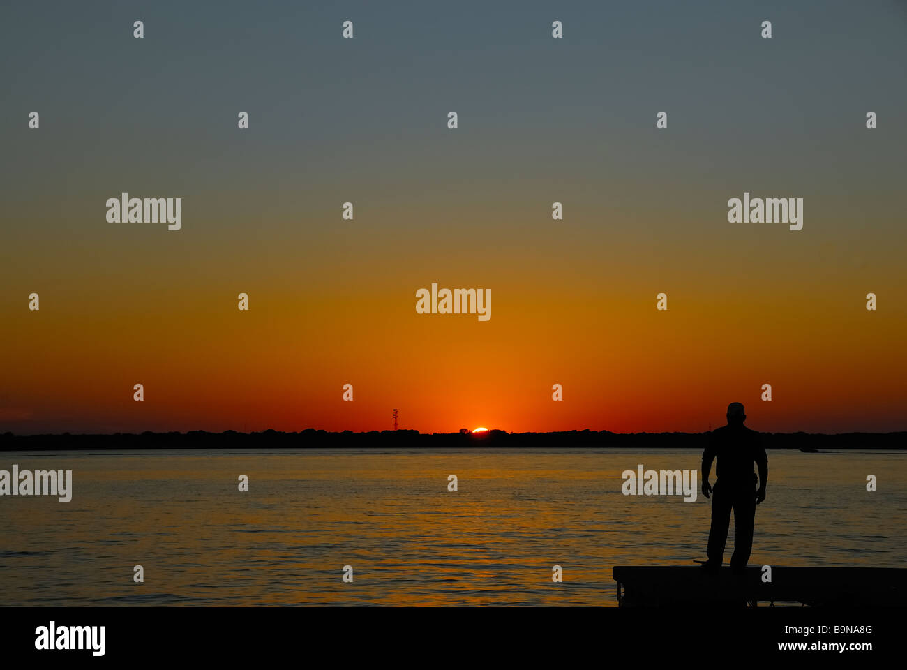 Silhouette of a man looking at the sunset Stock Photo - Alamy