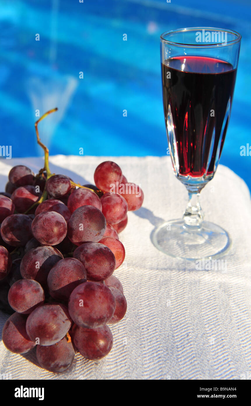 Red grapes and red wine by the swimming pool Stock Photo - Alamy