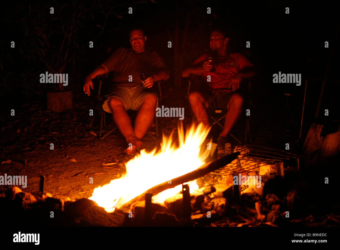 Two men sitting by fire, Australia Stock Photo - Alamy