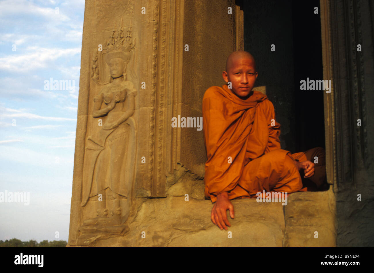 Buddhist monk sitting in a window frame in Angkor Wat, Cambodia Stock ...