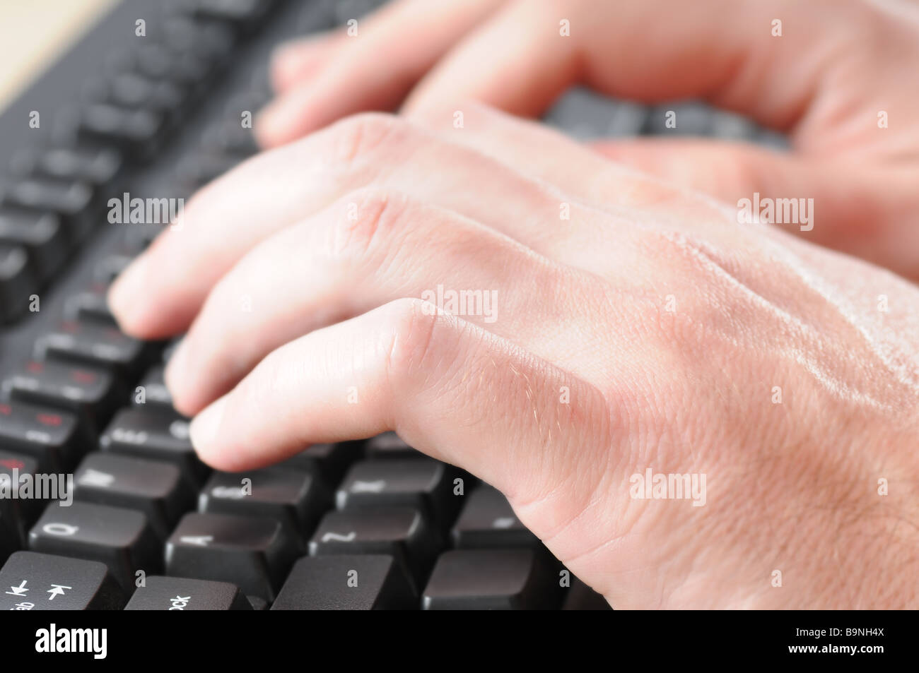 High contrast detail of hands on black computer keyboard Stock Photo ...