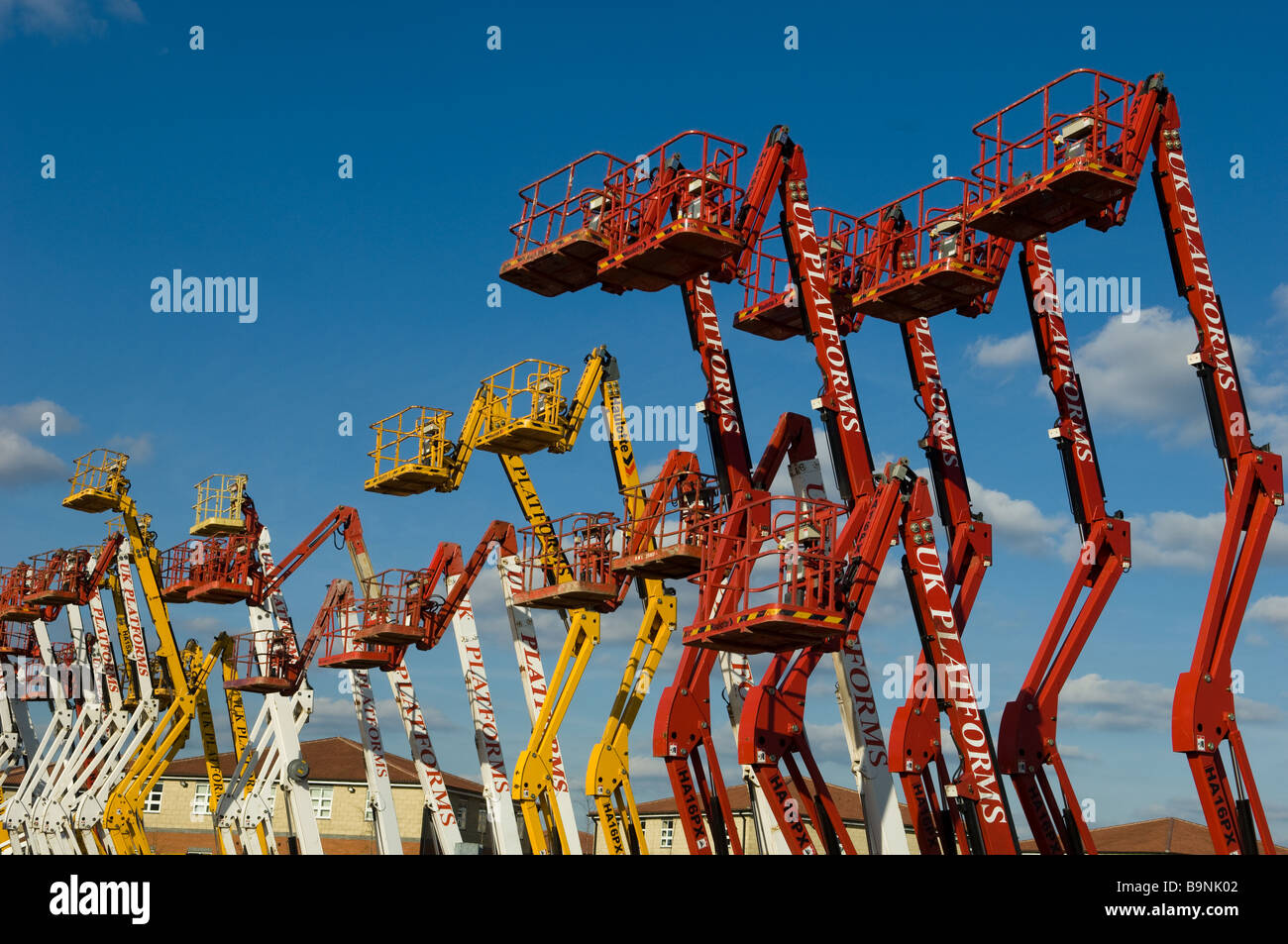 Cherry pickers linned up in the stockyard Stock Photo - Alamy