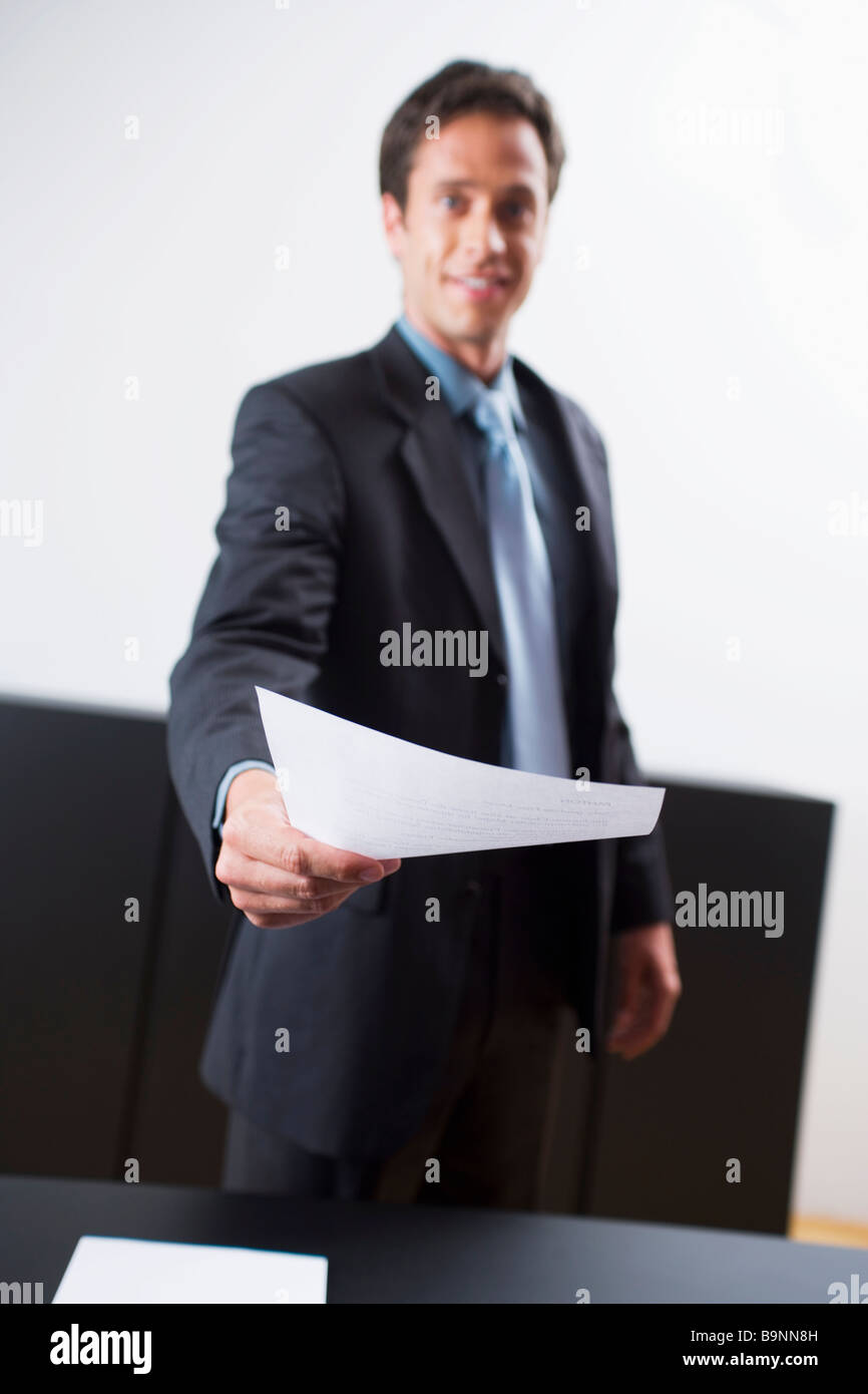 portrait of businessman handing over document Stock Photo - Alamy