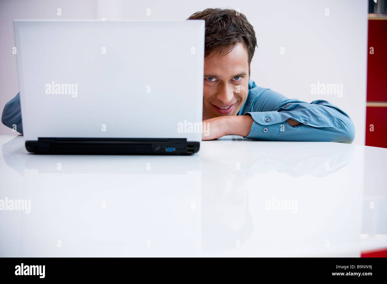 portrait of businessman peeking behind laptop computer Stock Photo - Alamy