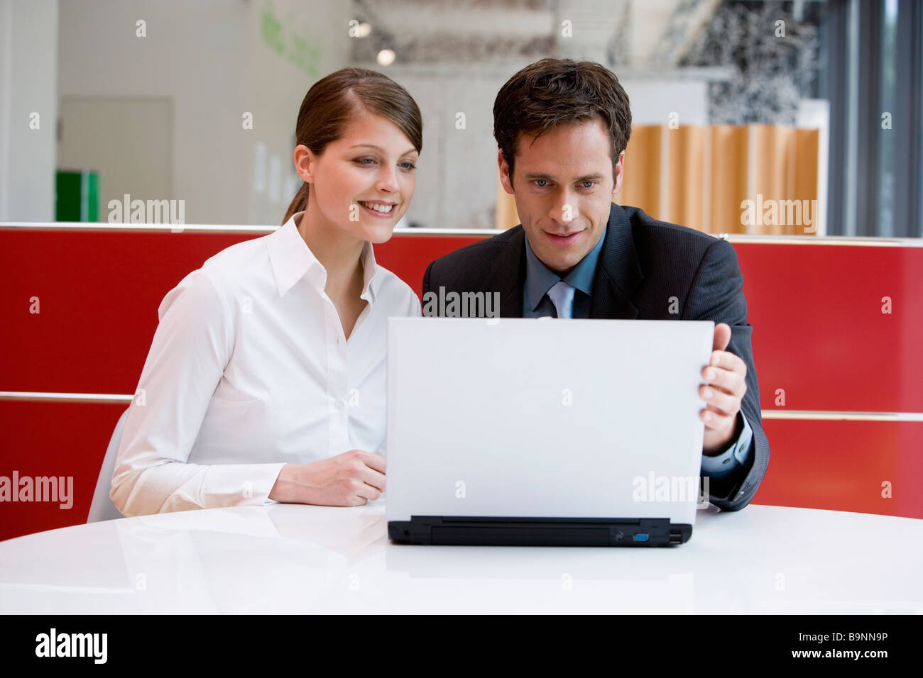 two business people working at laptop together Stock Photo - Alamy
