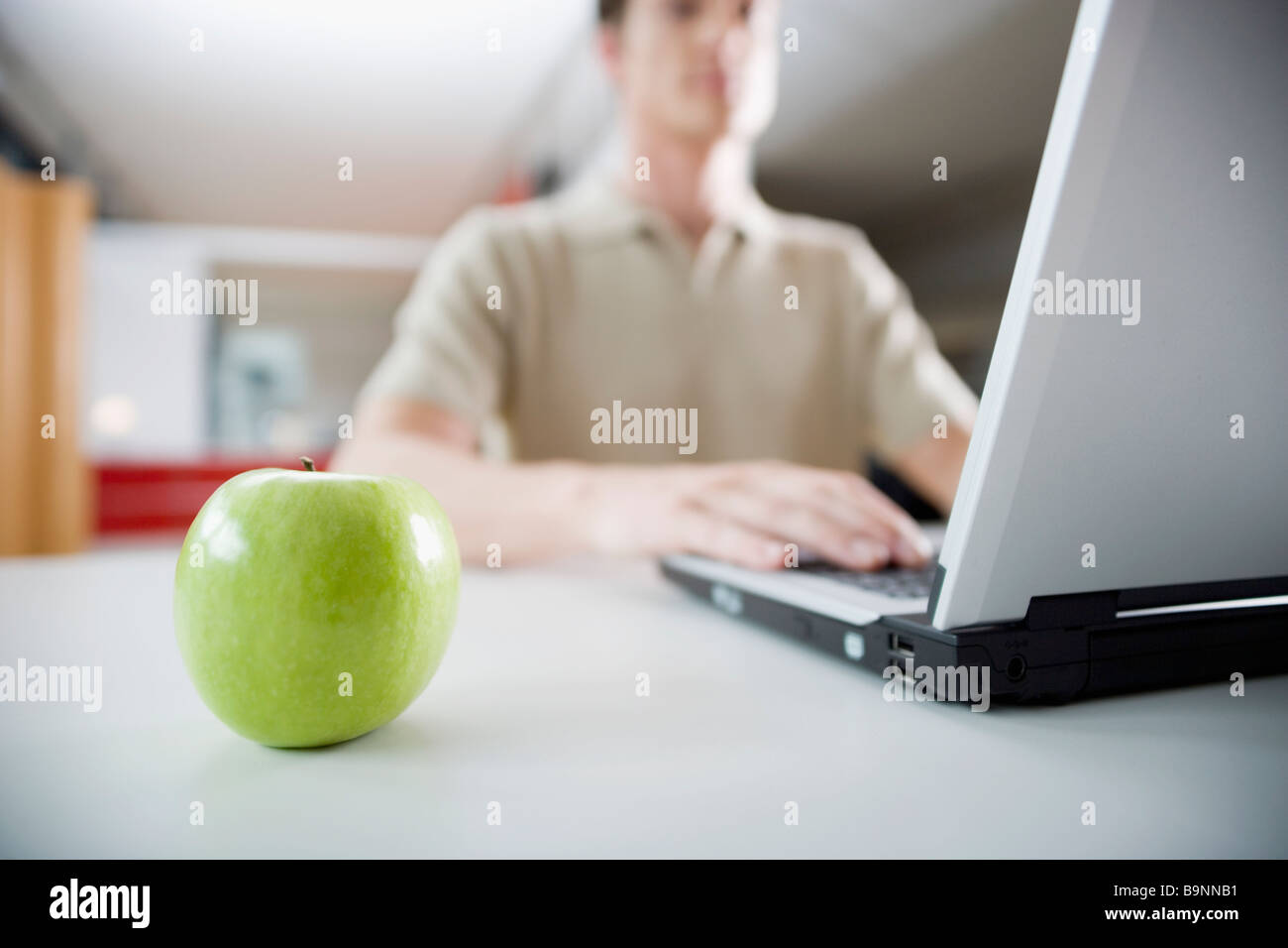green apple on desk with businessman working on laptop computer Stock ...