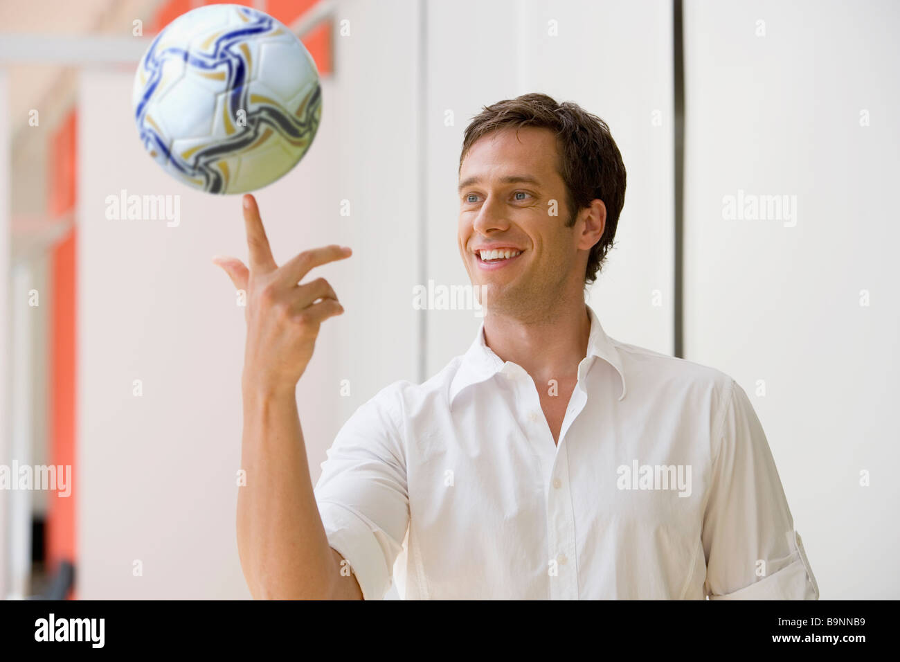 portrait of office worker balancing football on finger Stock Photo - Alamy