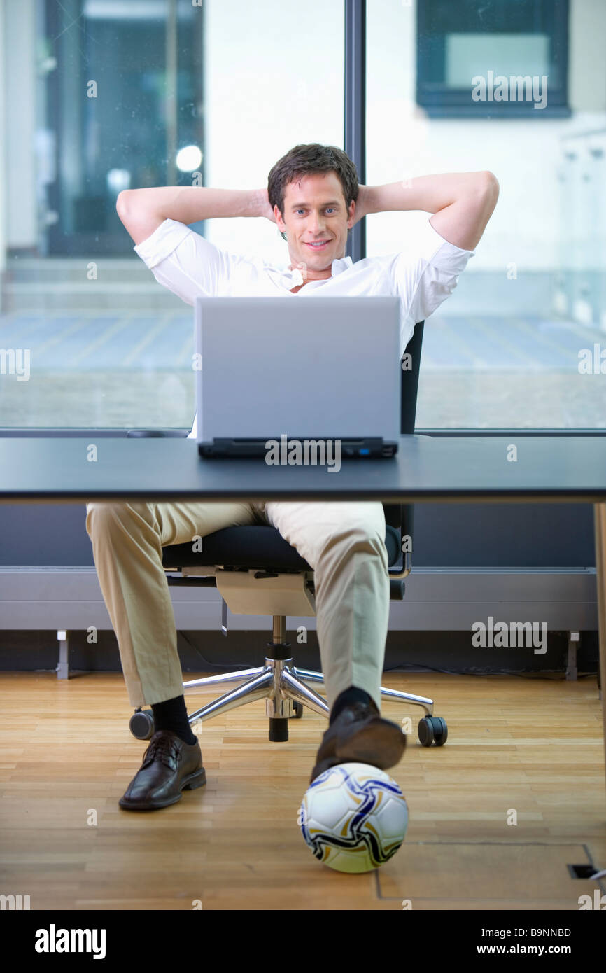office worker working with laptop computer having football under the ...