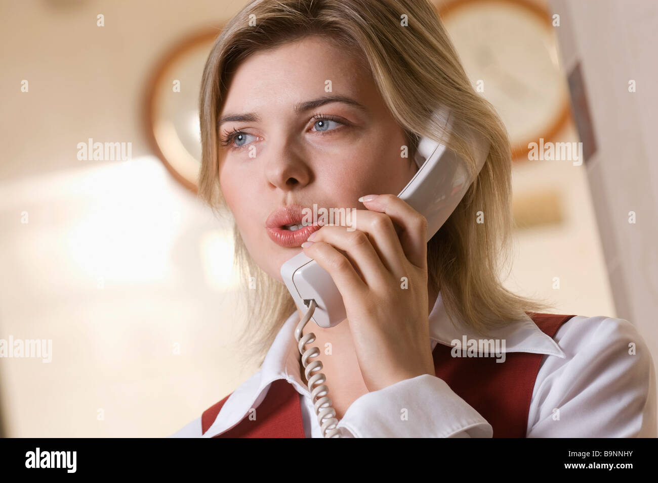 headshot of young hotel receptionist talking on telephone Stock Photo ...