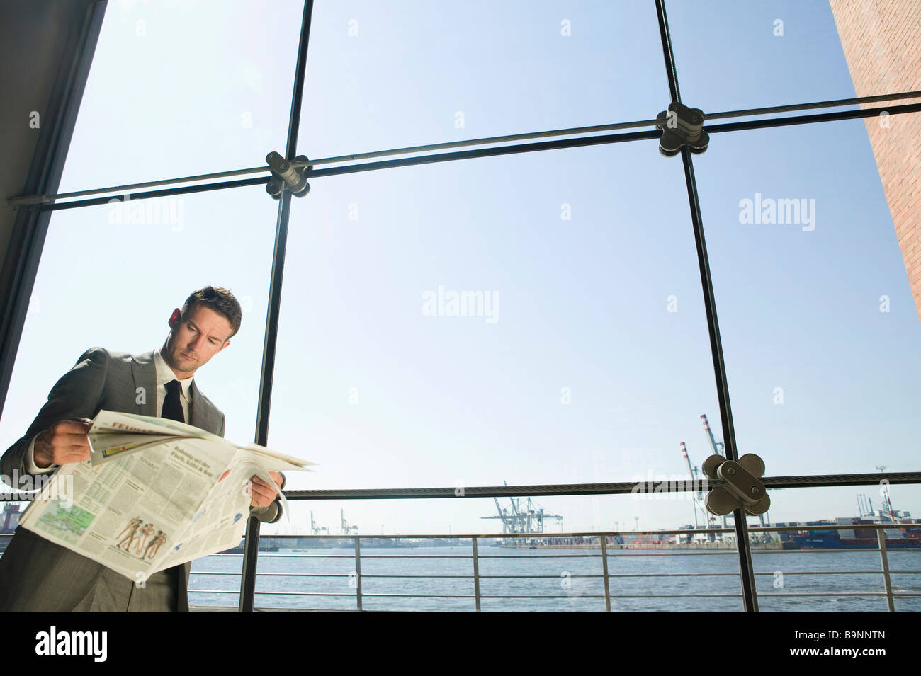businessman reading newspaper in front of window Stock Photo - Alamy