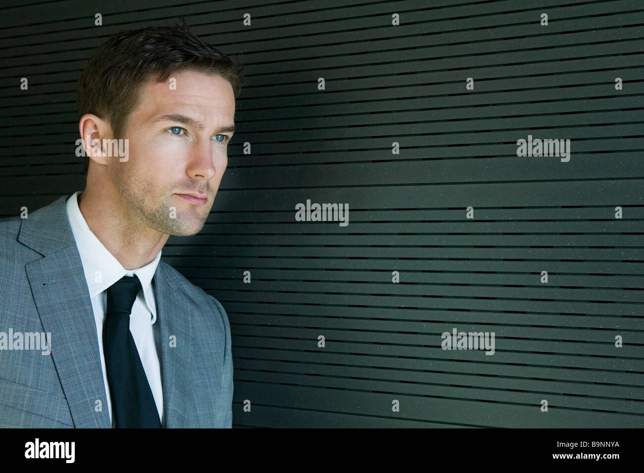 portrait of businessman in front of wall Stock Photo - Alamy