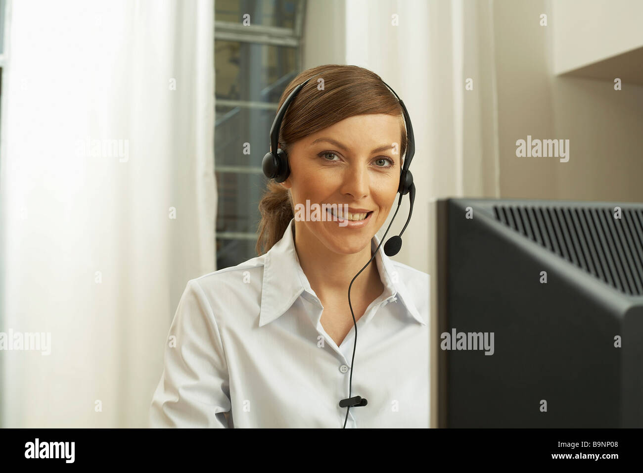 portrait of female call center agent sitting at computer Stock Photo ...