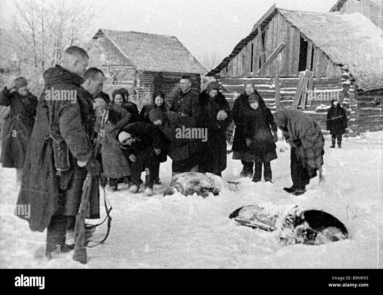Soviet soldiers and civilians examining bodies of people tormented to ...
