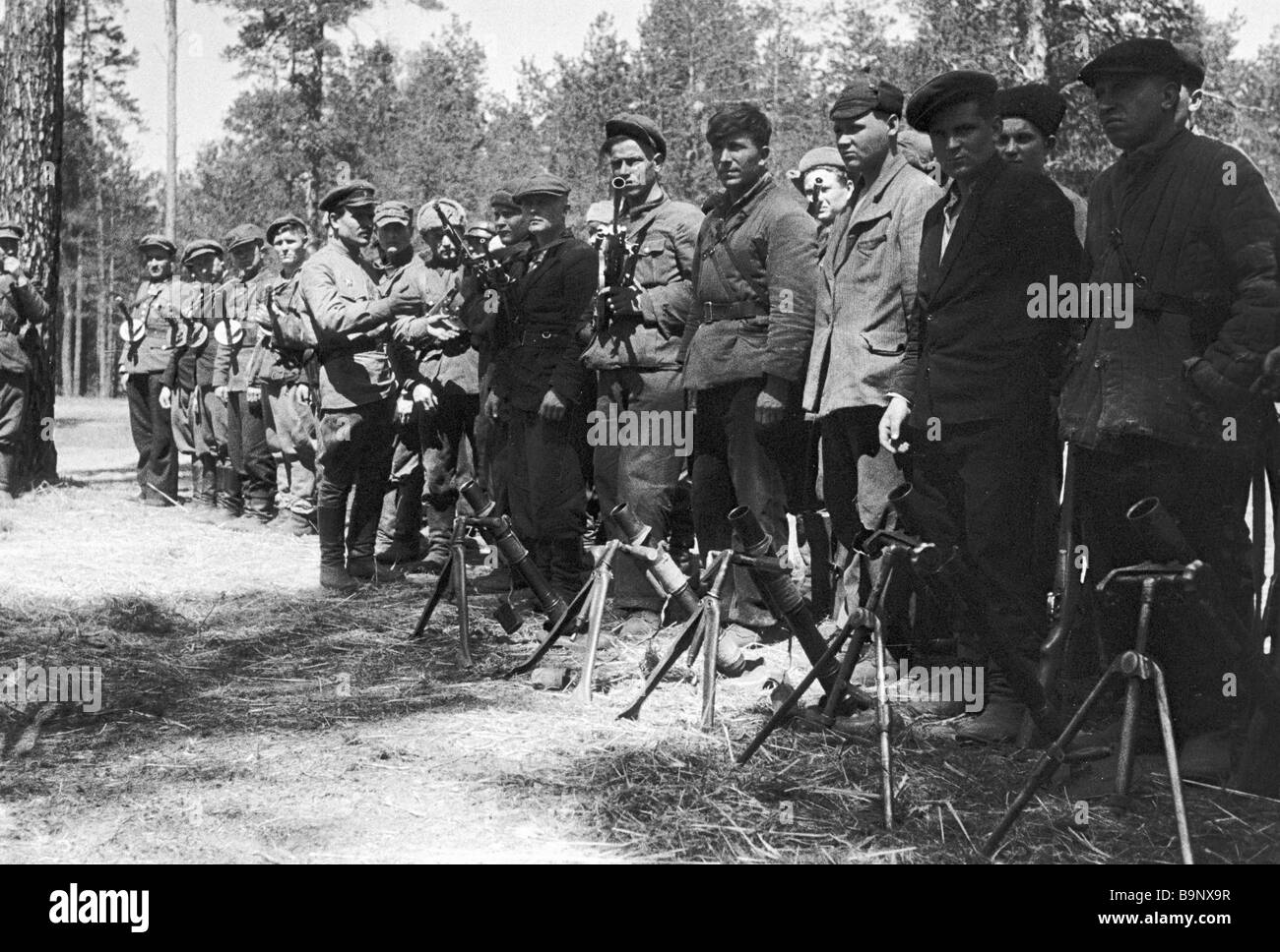 A Red Army man handing a gun to Byelorussian guerrillas Stock Photo - Alamy