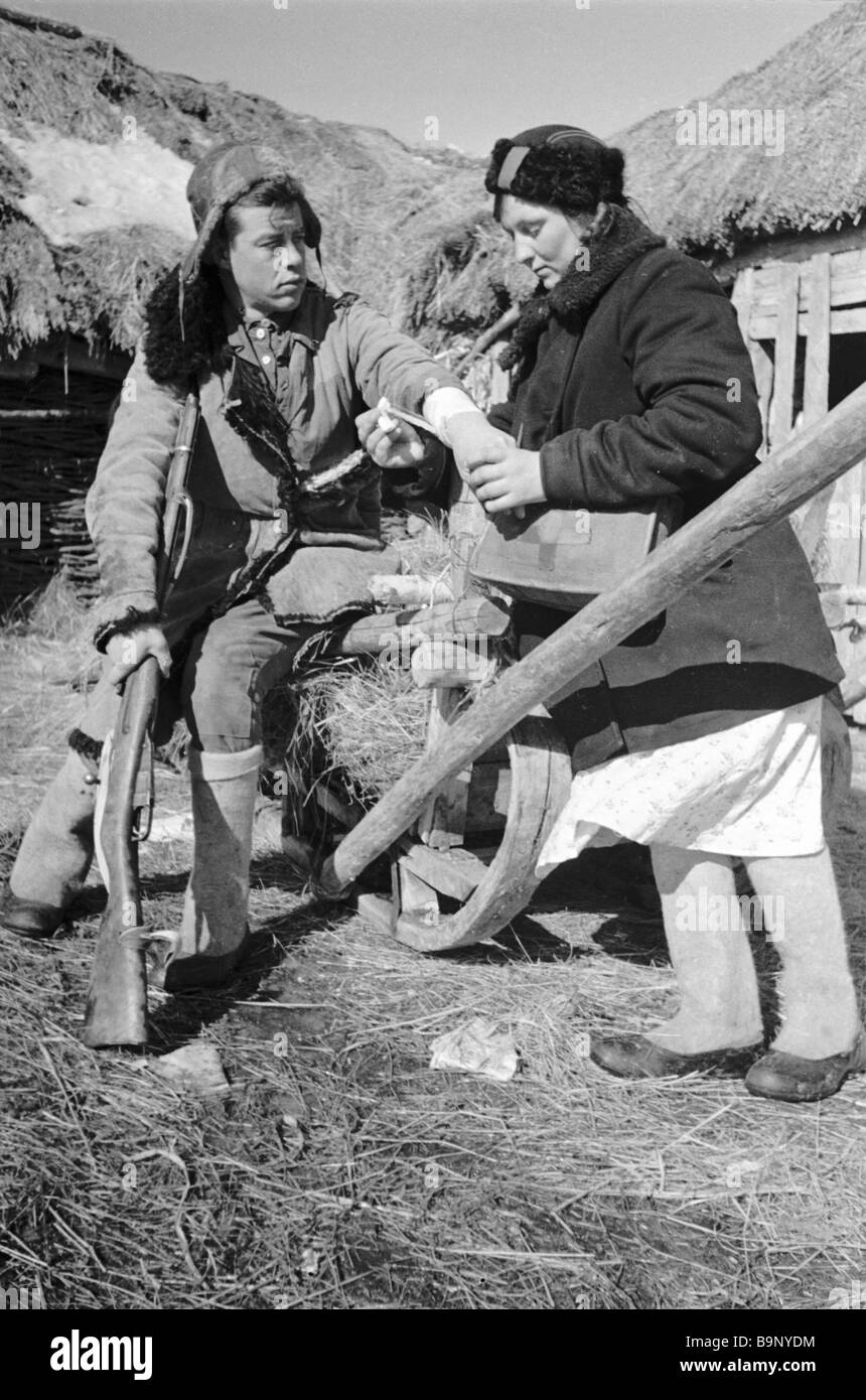A nurse helping a wounded soldier in the Frunze guerrilla unit Stock ...