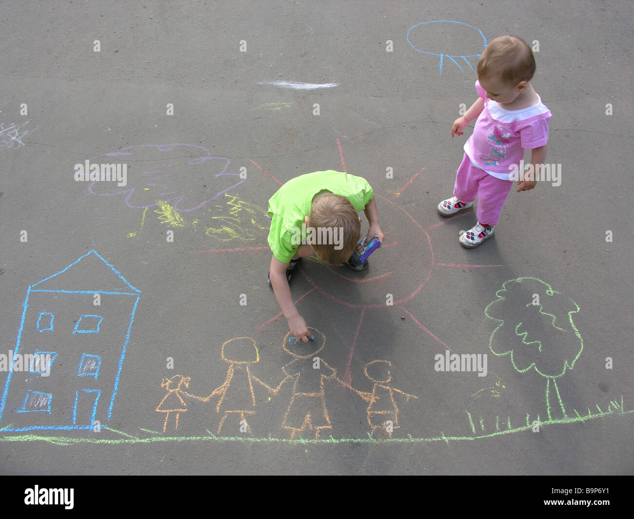 children drawing on asphalt family house Stock Photo - Alamy