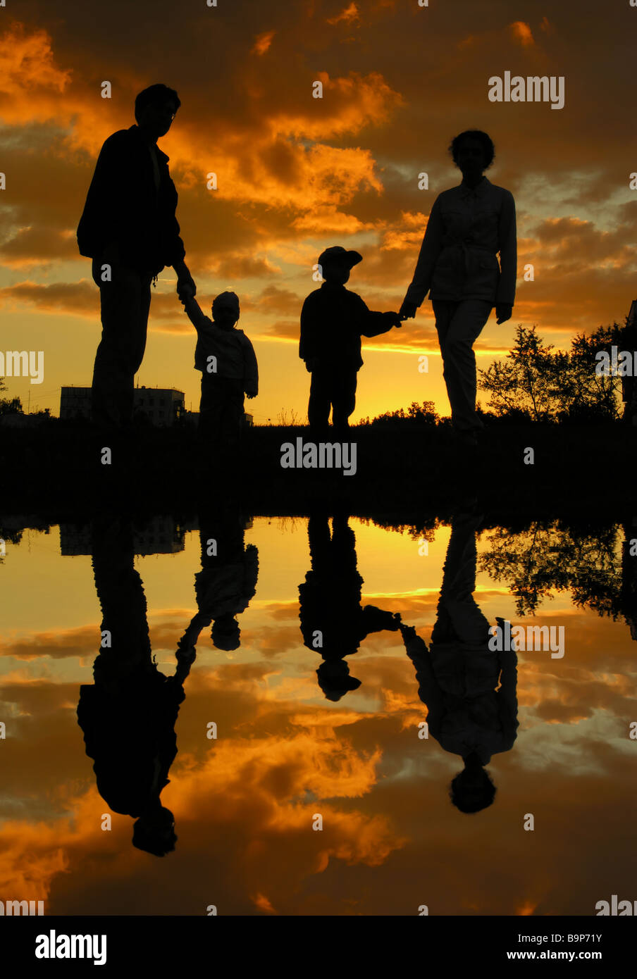 family of four sunset 2 and water Stock Photo - Alamy