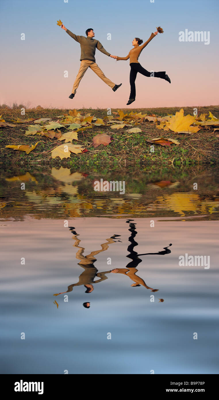 jump couple. autumn leaves. sunset water Stock Photo - Alamy