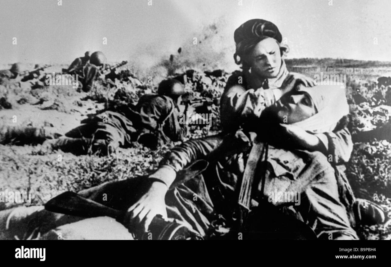 Medical instructor rendering first aid to a wounded soldier Stock Photo ...