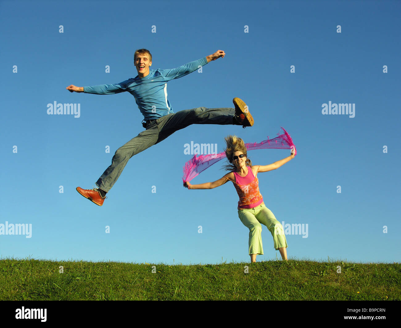 couples jump on grass Stock Photo - Alamy