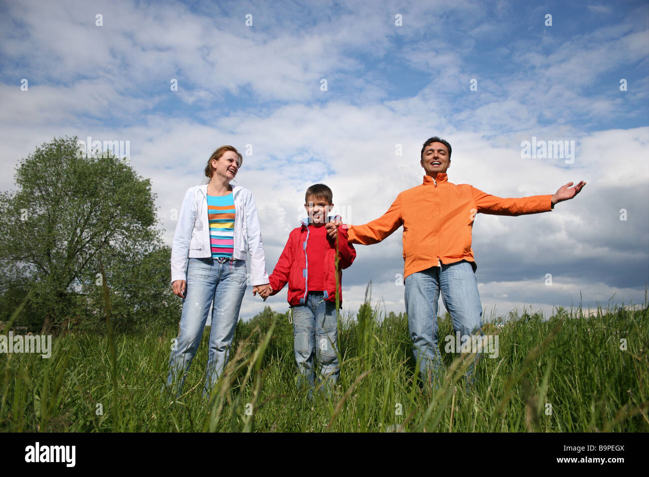 happy family stand in grass Stock Photo - Alamy