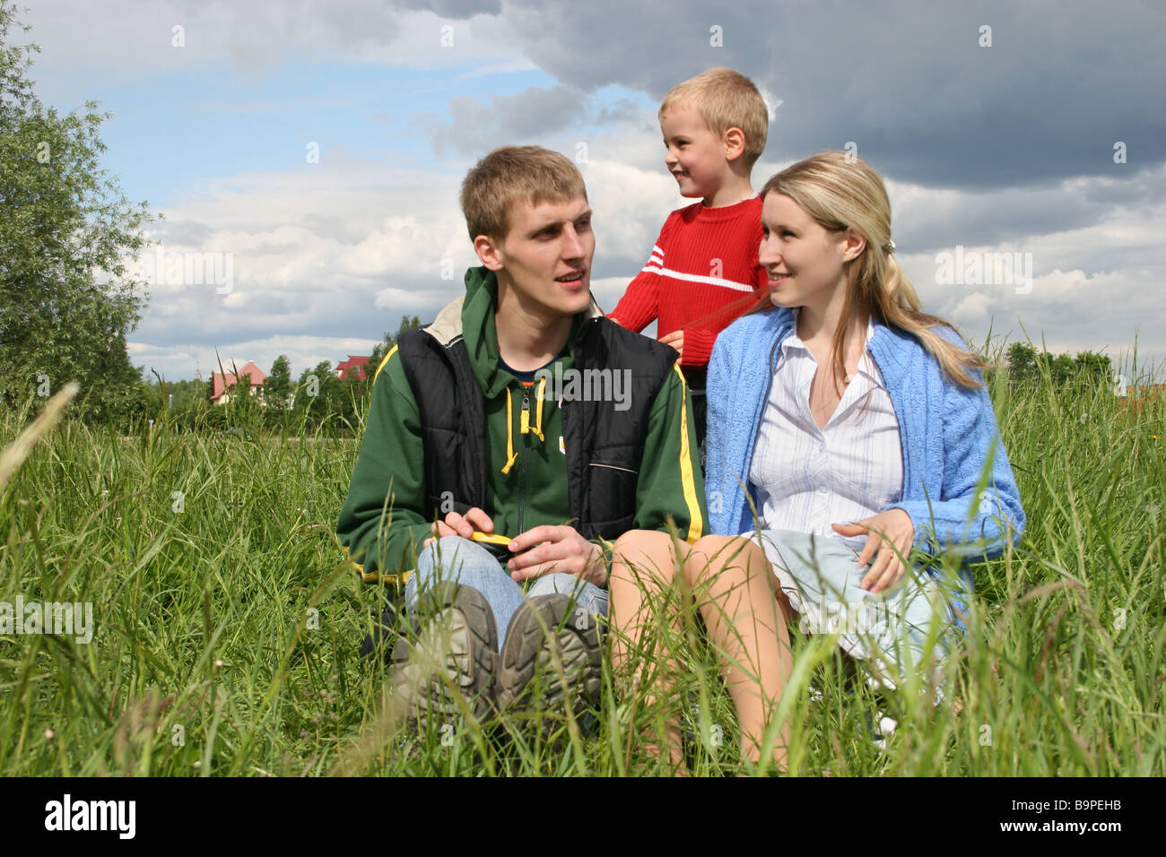 family on meadow waiting next child Stock Photo - Alamy